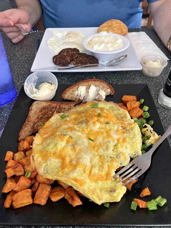 This isn't just an omelet—it's a fluffy yellow canvas painted with cheese, surrounded by sweet potato cubes that taste like morning sunshine.