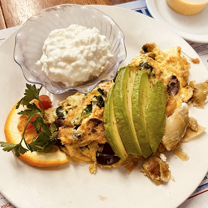 This isn't just an omelet—it's a garden party with avocado as the guest of honor and cottage cheese playing a supporting role.