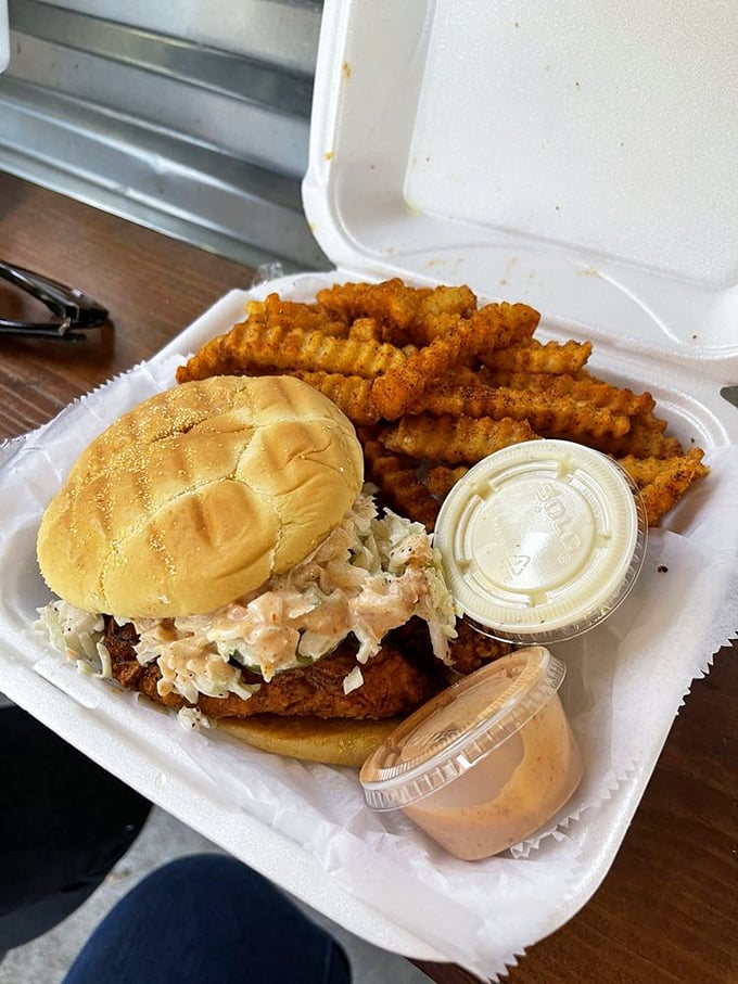 The hot chicken sandwich in its natural habitat—surrounded by crinkle-cut fries and accompanied by cooling sauce. A perfect harmony of crunch, heat, and relief.