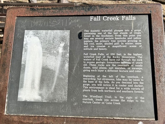 This weathered sign tells the waterfall's ancient story, though the graffiti suggests some visitors were more interested in leaving their own chapter.