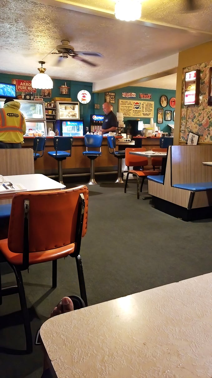 The counter seating—where solo diners become regulars, and regulars become family in this teal-walled temple of breakfast devotion.