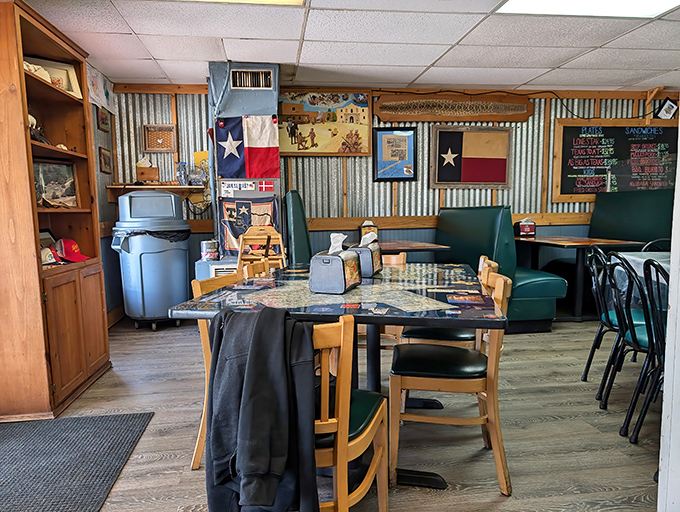 Texas pride on full display. The corrugated metal walls, Lone Star flags, and wooden tables create an atmosphere as authentic as the smoke ring.
