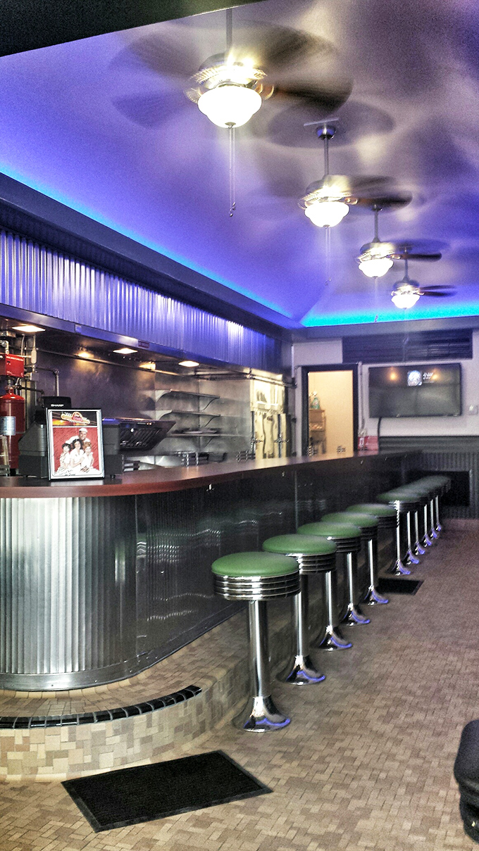Counter seating illuminated by blue accent lighting—where solo diners become regulars and the breakfast magic happens mere feet from your hungry eyes.
