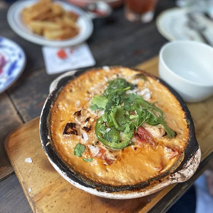 The Moqueca Stew arrives bubbling with promise—a Brazilian-inspired seafood symphony that makes you forget you're hundreds of miles from any coast.