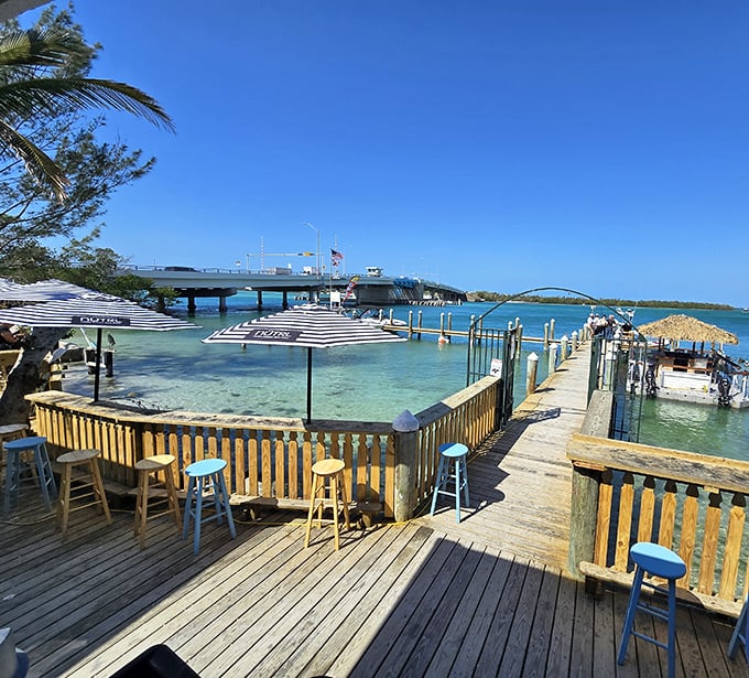 Bar stools with a view that makes you forget what you ordered. Paradise isn't always about white tablecloths—sometimes it's weathered wood and turquoise waters.