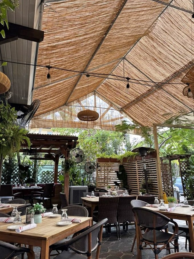 Dining al fresco under bamboo shades, surrounded by greenery—it's like eating in Hemingway's Cuban garden, minus the six-toed cats.