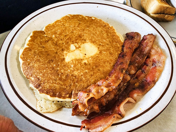 The golden-brown pancake and perfectly crisp bacon represent breakfast in its purest form—simple perfection that needs no Instagram filter.