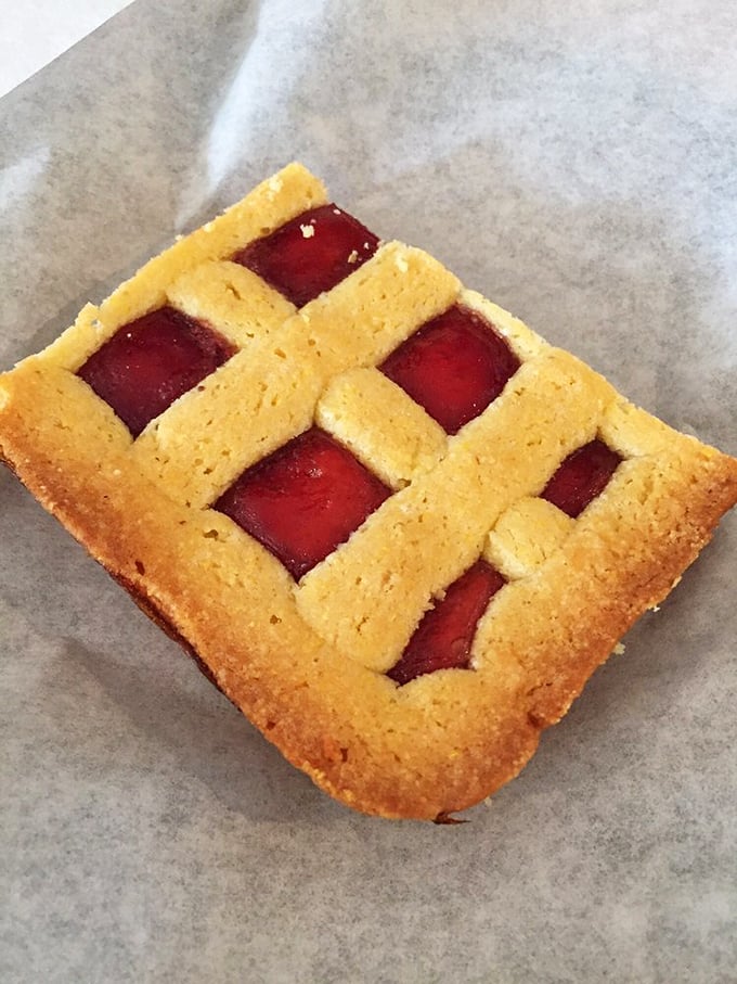 This raspberry square isn't just dessert – it's edible stained glass, a perfect balance of buttery crust and tangy fruit.