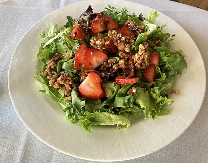 A salad that actually excites—fresh greens, sweet strawberries, and candied nuts creating a symphony of textures that makes eating vegetables feel indulgent.