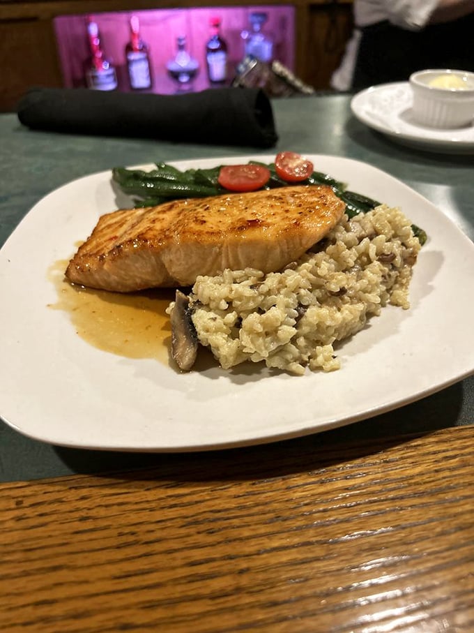 Salmon that's actually cooked properly—moist, flaky, and perched atop a bed of risotto like it's posing for a food magazine.