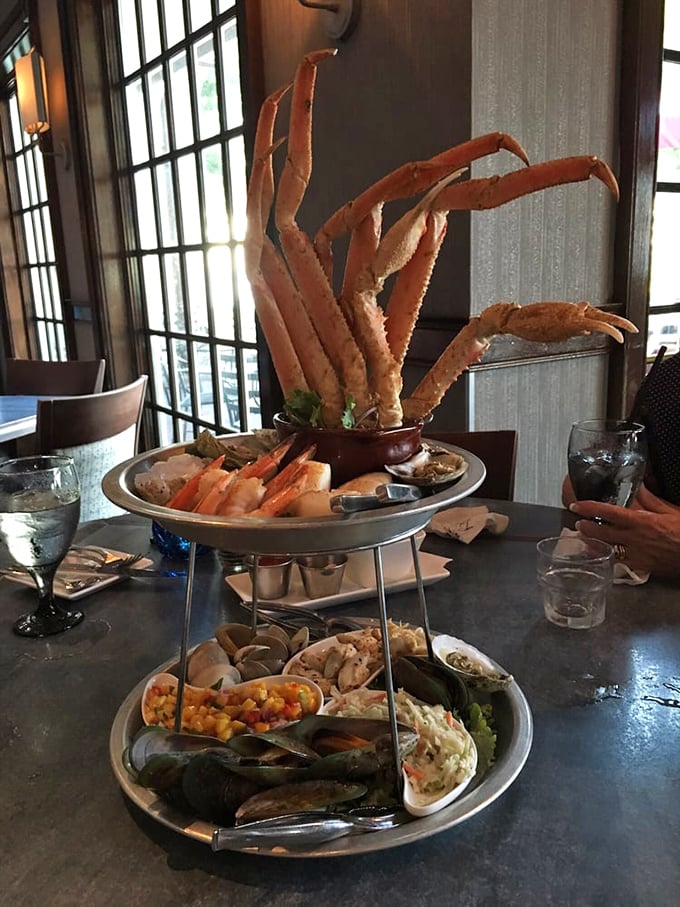 The seafood tower isn't just a meal—it's an architectural achievement where crab legs reach skyward like they're trying to return to the ocean.