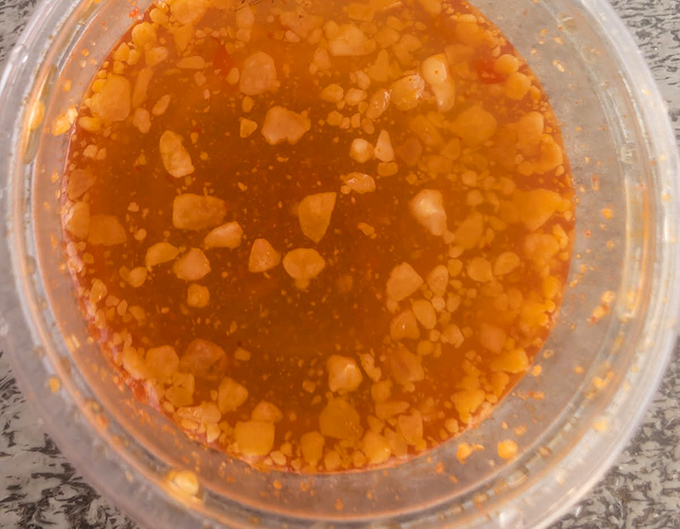 The sauce that launches a thousand return trips—a sweet, spicy, garlicky elixir that would make cardboard taste good, though it deserves better company.