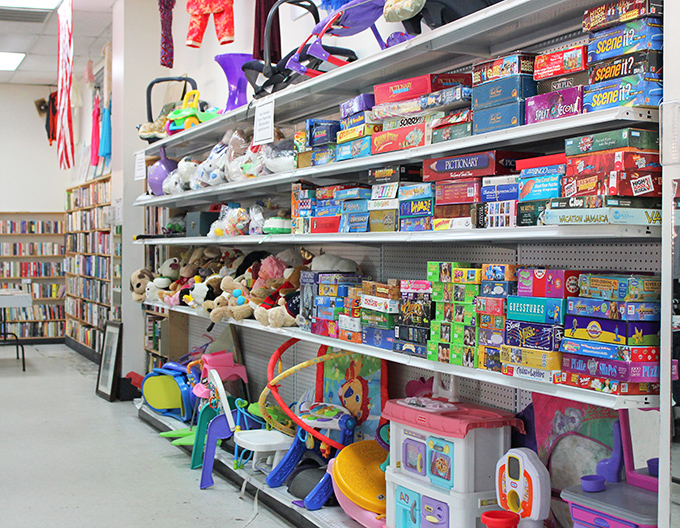 Childhood joy stacked on metal shelves – from barely-loved stuffed animals to board games with all their pieces, miraculously intact and ready for new adventures.