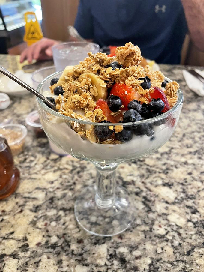 A parfait that's practically wearable art – layers of yogurt, fresh berries, and crunchy granola in a glass that screams "I'm being healthy-ish!"