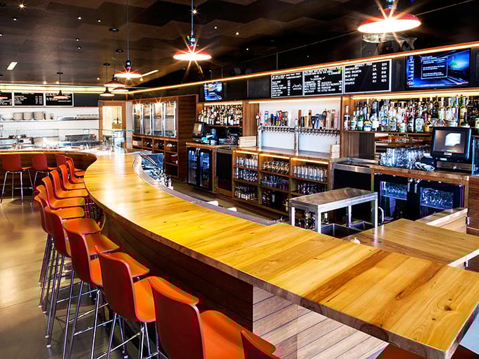 The bar at Connie and Ted's isn't just where drinks are made—it's command central for seafood dreams, with those orange chairs practically begging for happy hour stories.