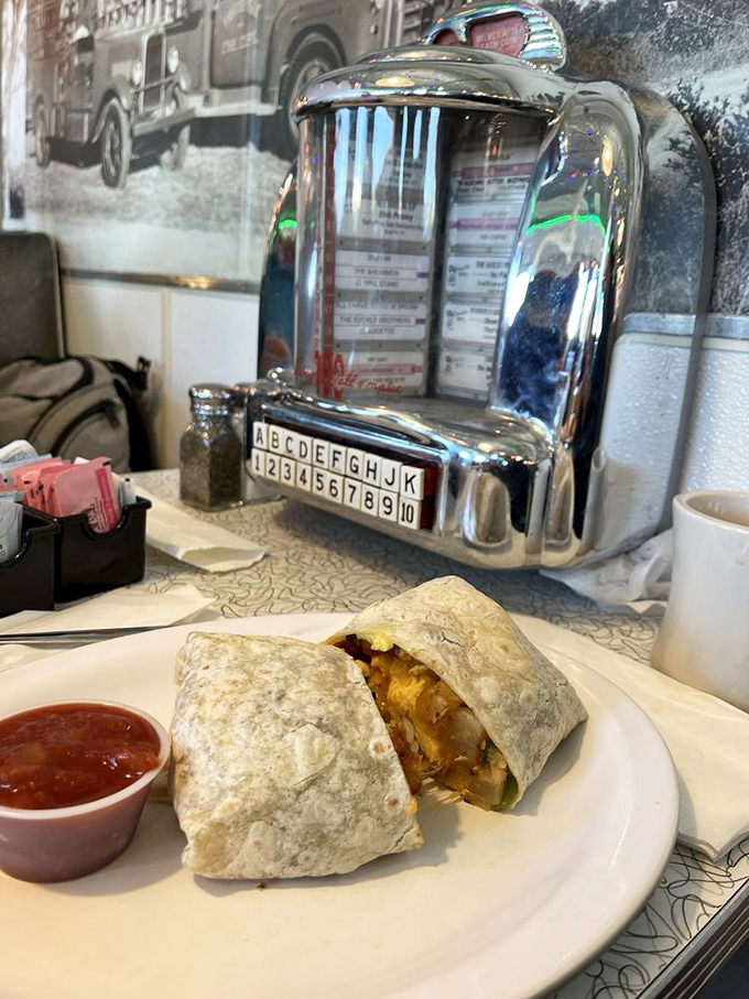 The breakfast burrito that makes mornings worth facing. Nestled beside a tabletop jukebox, it's a time-traveling taste experience.