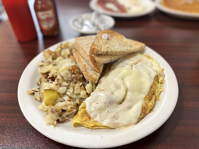 An omelet draped in country gravy isn't just comfort food—it's a warm hug from the Midwest that stays with you all day.