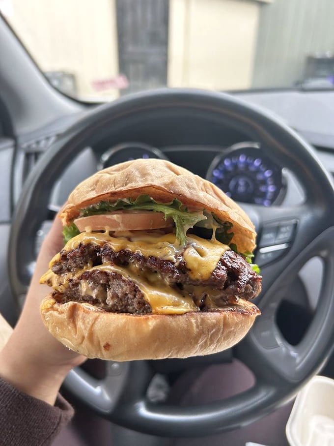 Car dashboard dining at its finest. This burger doesn't care about your upholstery—it demands to be devoured immediately.