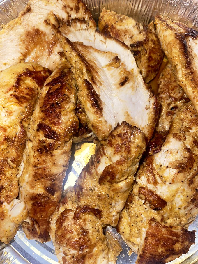 Seasoned, grilled chicken that looks like it's been kissed by fire gods. This isn't just protein—it's a masterclass in marinade.