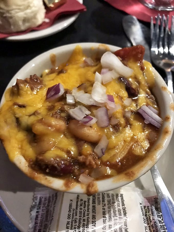 A bowl of hearty chili topped with melted cheese and diced onions—winter comfort that works even when you're not snowed in.