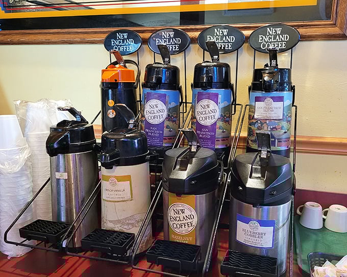 Coffee station that means business—multiple flavors standing at attention like caffeinated soldiers ready for morning duty. The kind of setup that makes Monday mornings slightly less criminal.