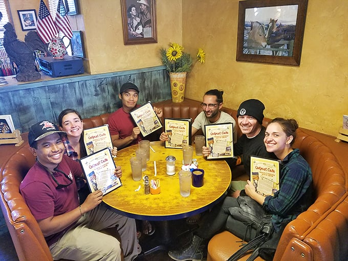 Happy diners showing off their menus like winning lottery tickets—the universal expression of "we found the good place."
