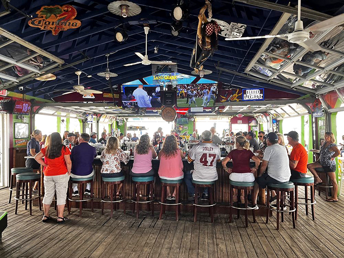 The dock bar at full tilt – where locals and tourists bond over Orange Crushes and football on screens large enough to see from your boat.