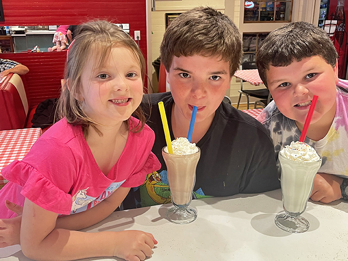 Milkshakes bringing smiles to young faces—proof that some joys transcend generations. These kids understand what happiness tastes like.