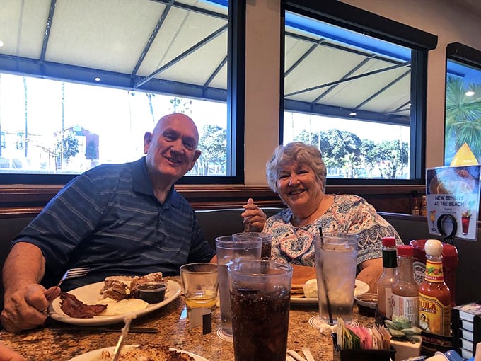 Happy diners sharing stories over plates that could double as weight-training equipment. This is breakfast as a social event.