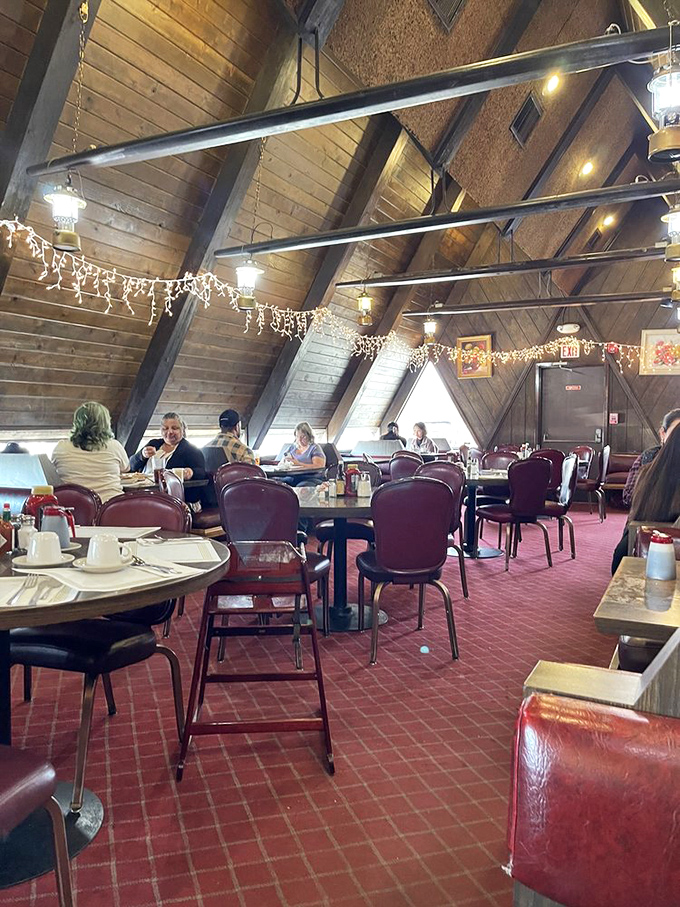 The dining room buzzes with conversation under dramatic wooden beams. Notice the string lights—they're not just for Christmas, they're for ambiance year-round.