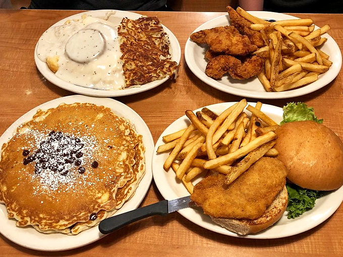 The table groans under a feast that spans breakfast to lunch, with pancakes and sandwiches playing supporting roles to crispy fries.