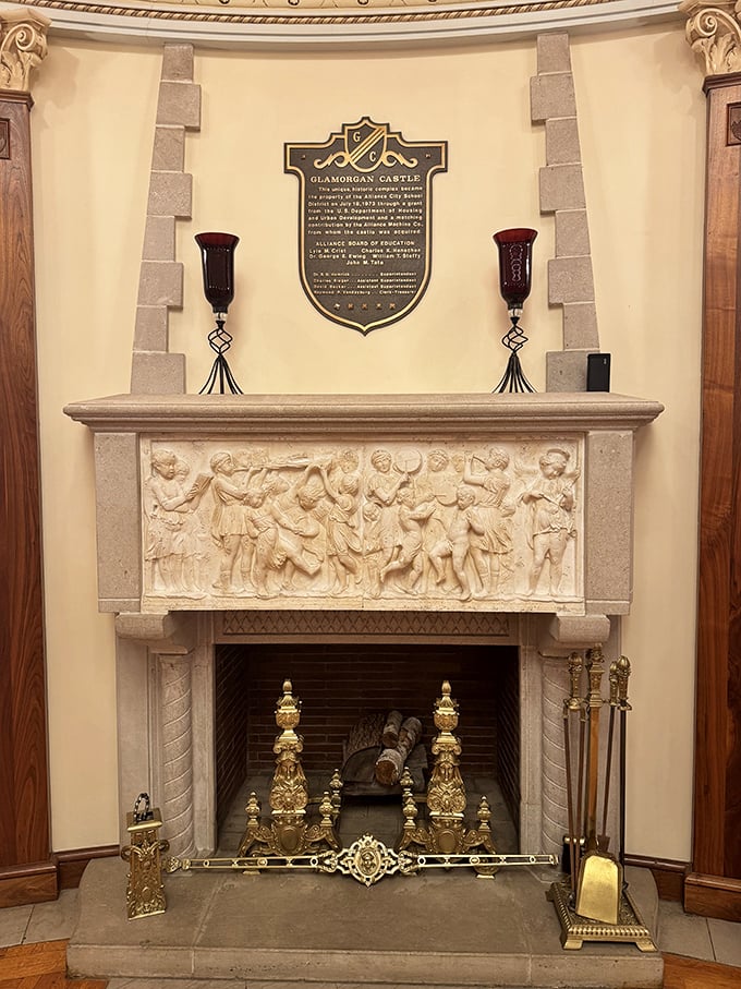 This isn't just a fireplace—it's a stone canvas telling stories through intricate carvings, topped with a plaque that reminds us we're standing in history.