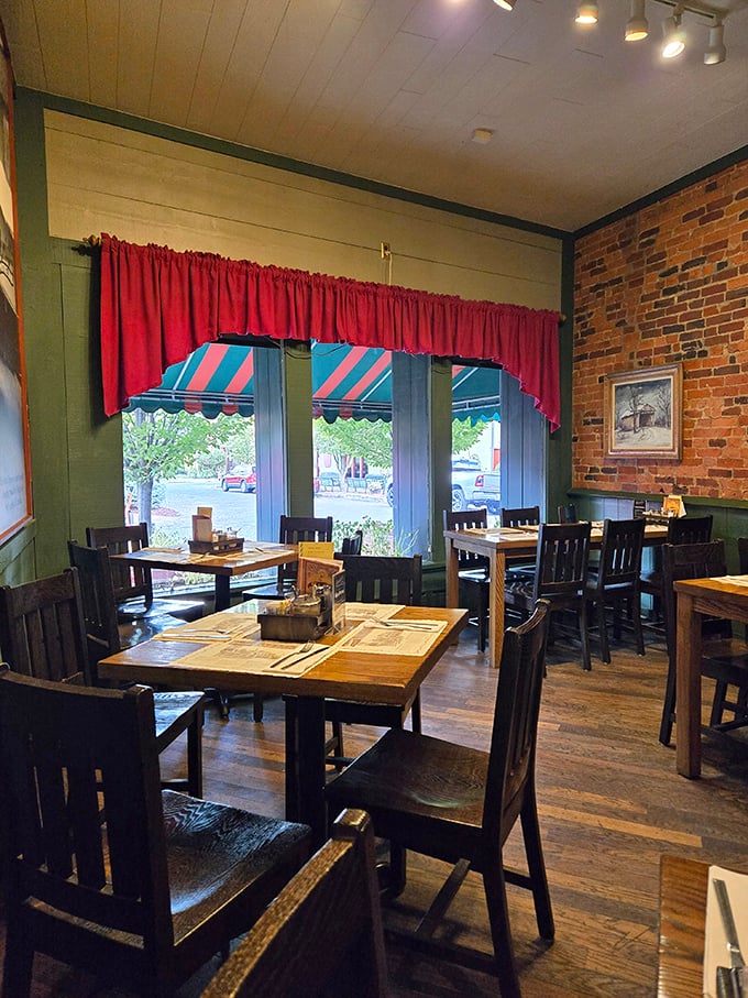 Red curtains frame windows overlooking Main Street, while wooden tables await hungry patrons in a dining room that feels both spacious and cozy.