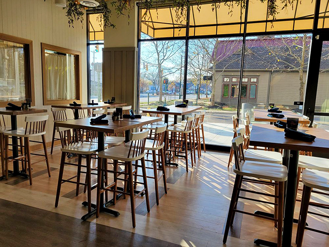 Sunlight streams through floor-to-ceiling windows, bathing high-top tables in golden light. It's like they designed the perfect spot for both eating and being seen.
