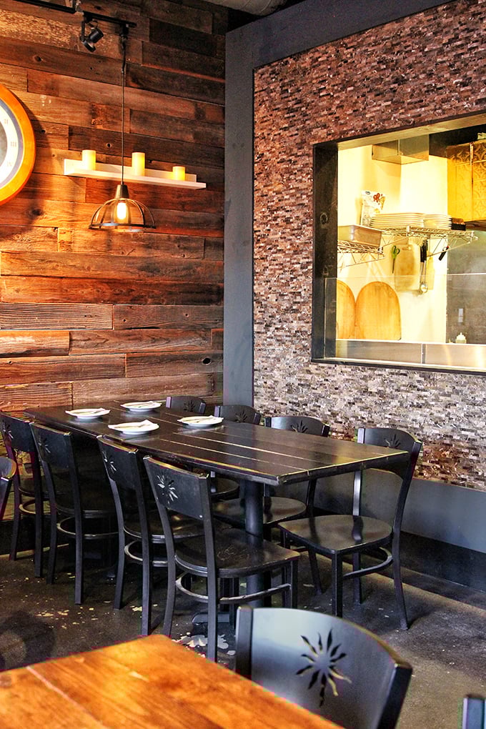 The marriage of rustic wood and textured stone creates a dining space that feels both modern and timeless—like dining in a very stylish cave.
