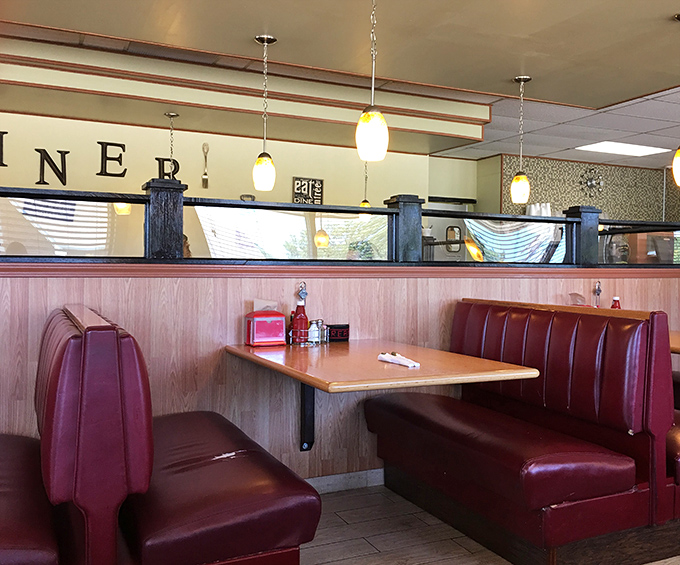 Classic diner booths in that signature red – where family stories are shared and coffee refills appear like magic between sentences.
