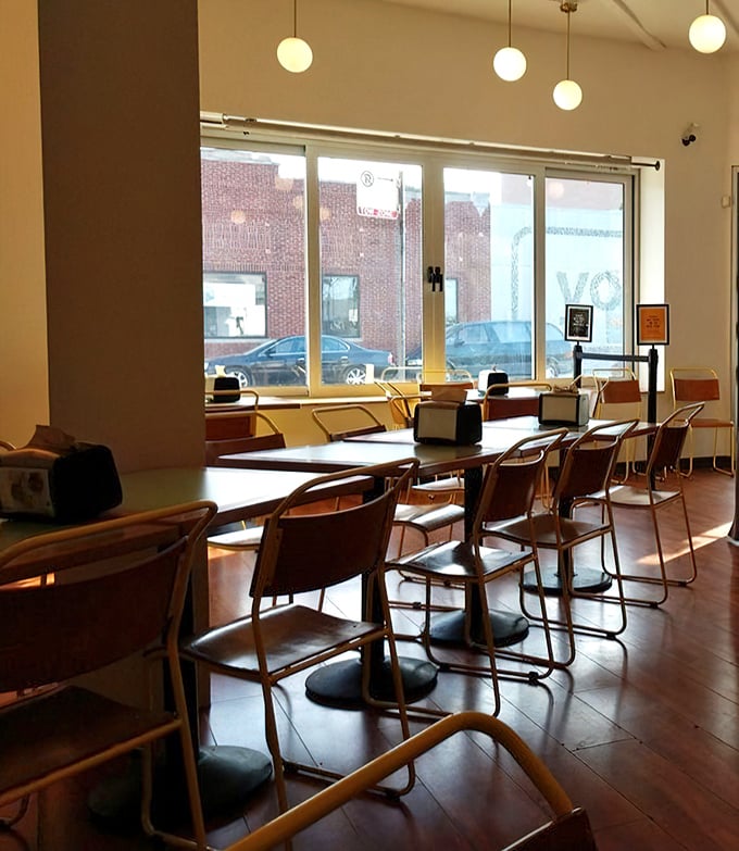 Minimalist interior with wooden tables, globe lighting, and large windows that let you people-watch while contemplating your next chicken order.