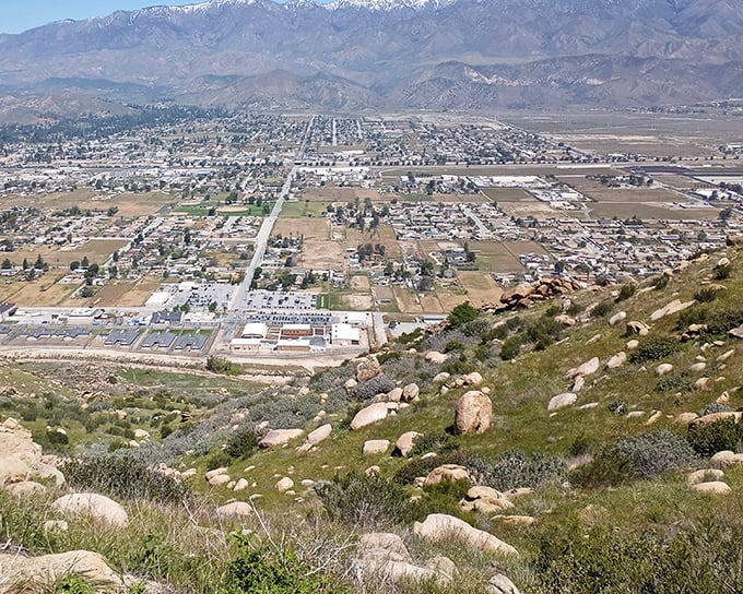 The valley sprawls below like a miniature model world – making you feel simultaneously tiny and somehow part of something enormous.