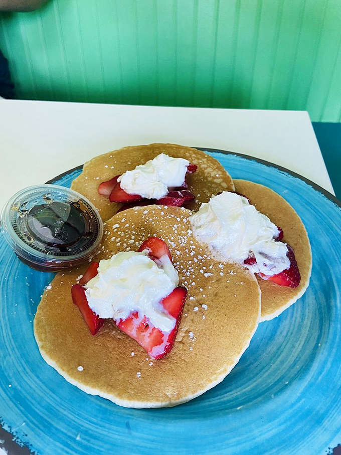 These pancakes aren't just breakfast—they're a pillowy canvas for fresh strawberries and whipped cream. Morning indulgence that feels like getting away with something.