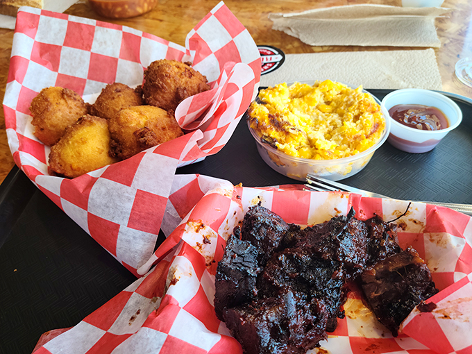 A barbecue trinity that would make any Texan nod in approval—burnt ends, hush puppies, and mac and cheese forming an unholy alliance of deliciousness.
