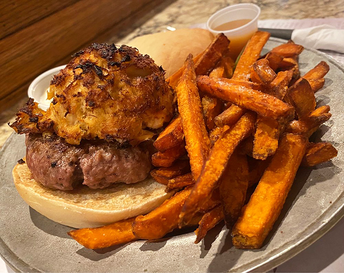 This isn't just a burger—it's a surf and turf masterpiece topped with what appears to be crab, proving that sometimes more really is more.