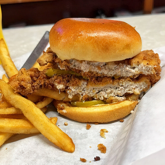 A tenderloin sandwich that requires strategic planning to eat. The meat-to-bun ratio suggests someone with a wonderful sense of humor.