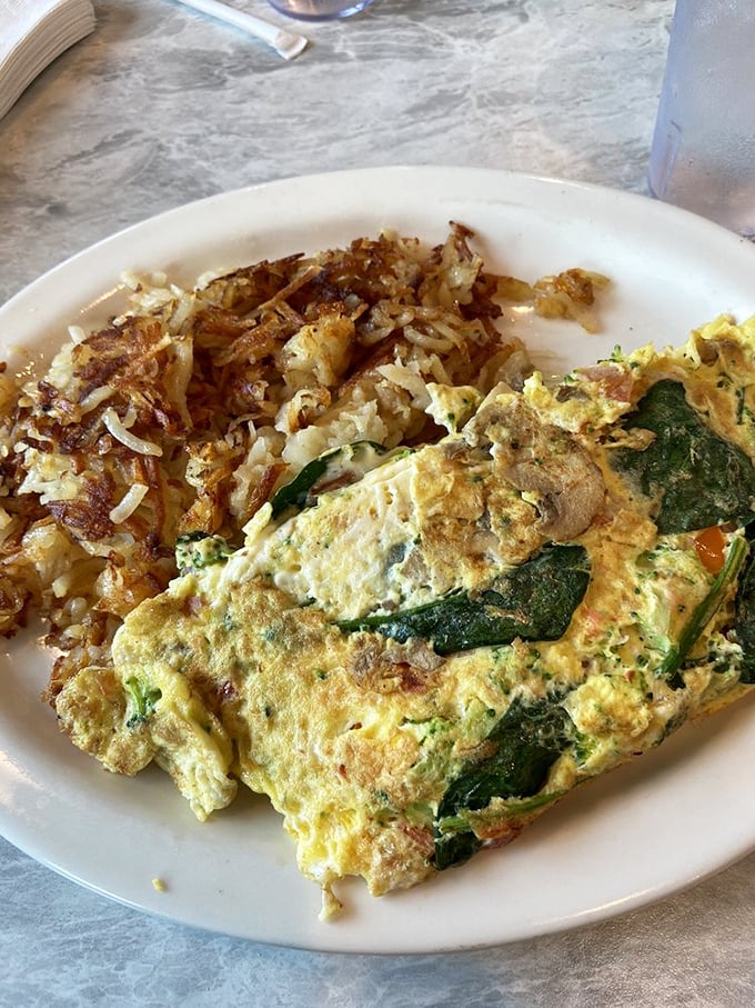 Garden-fresh meets griddle-perfect in this veggie omelet. Those crispy-edge hash browns aren't just a side dish—they're essential supporting characters.