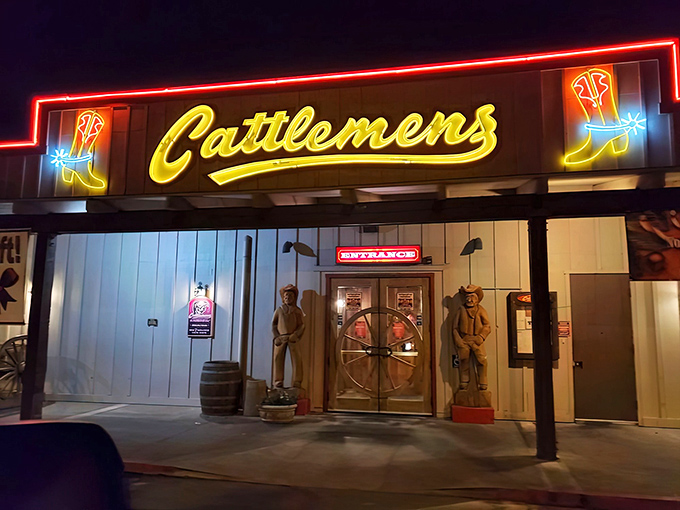 The neon cowboy boots flanking Cattlemens' sign aren't just decoration—they're beacons calling to hungry travelers like moths to a flame.