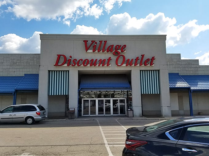 The iconic red signage of Village Discount Outlet stands like a beacon of bargain hope against the Ohio sky.