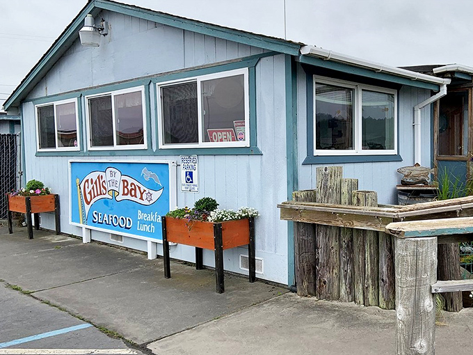 The classic blue-and-white exterior of Gill's By the Bay looks like a postcard from coastal California that accidentally became a restaurant.