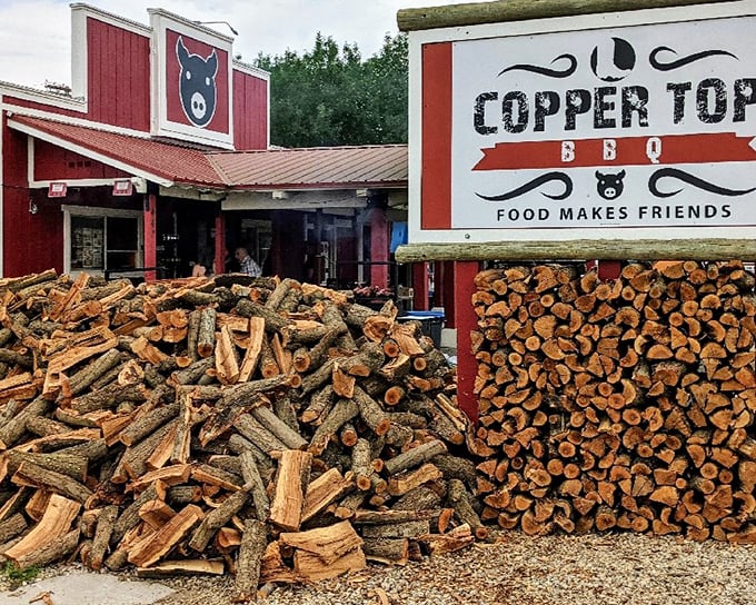 The patriotic red exterior of Copper Top BBQ stands as a beacon of hope for hungry travelers on Highway 395, American flags proudly announcing its barbecue allegiance.