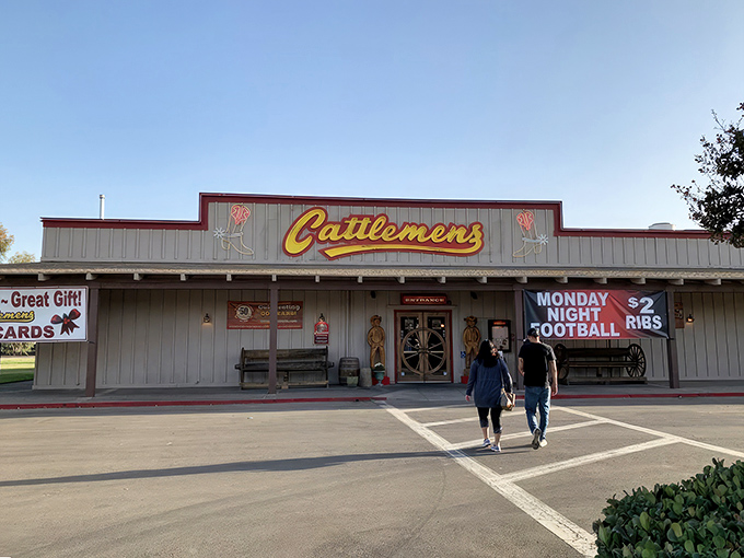 The iconic yellow Cattlemens sign welcomes hungry travelers like a beacon of beef-related bliss. Those wooden cowboys aren't just decorative—they're promising you the steak of your dreams.