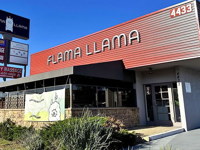The striking red exterior of Flama Llama stands out like a culinary lighthouse, beckoning hungry San Diegans with its playful name and artistic plate display.
