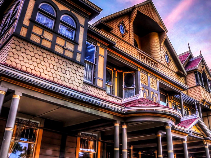 The Winchester Mystery House glows with eerie elegance at night, its Victorian façade hiding architectural oddities that would make M.C. Escher scratch his head in confusion.